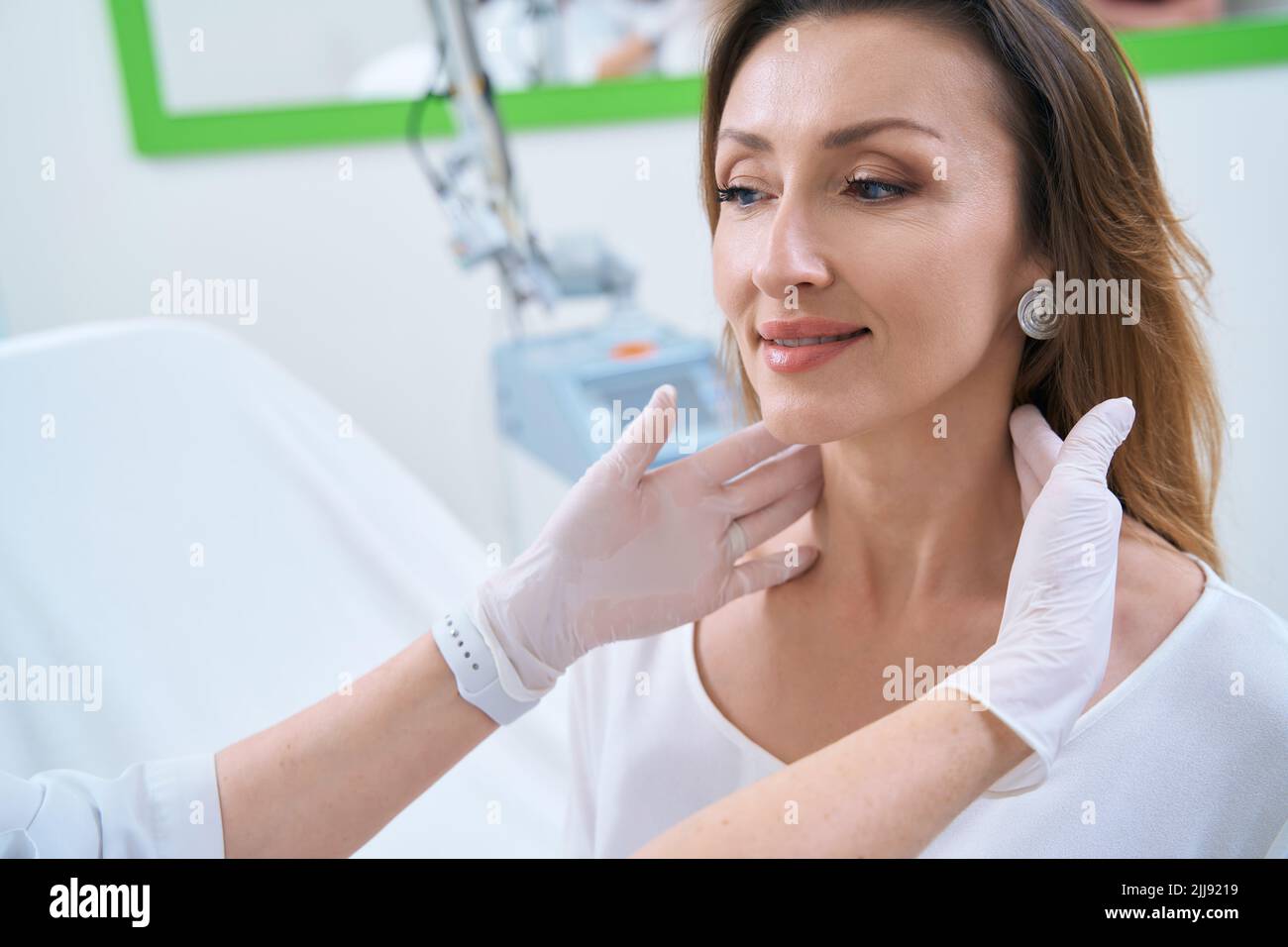 Woman touches neck hands on hi-res stock photography and images - Alamy