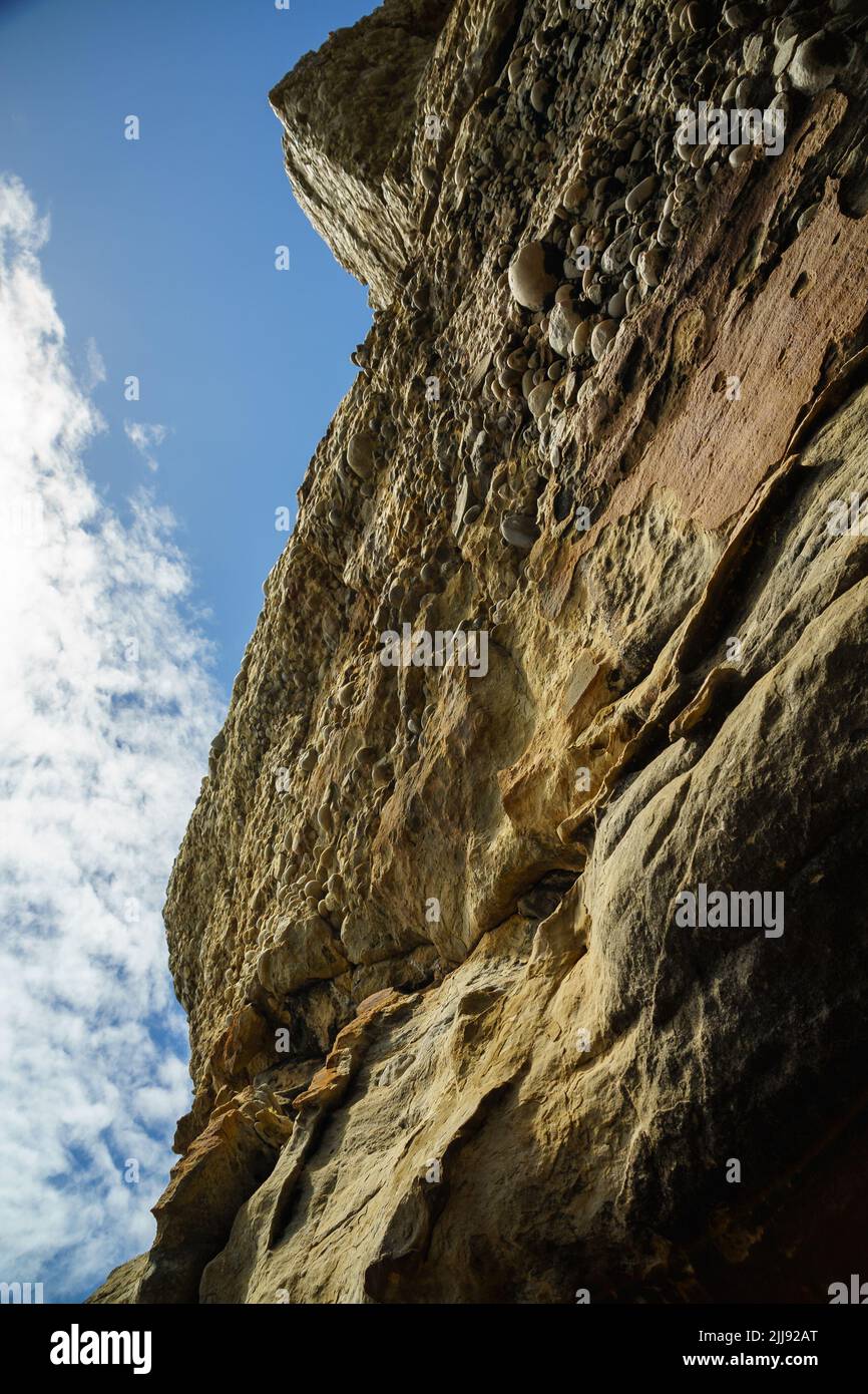 A vertical shot of a high rocky cliff under the clear blue sky Stock ...