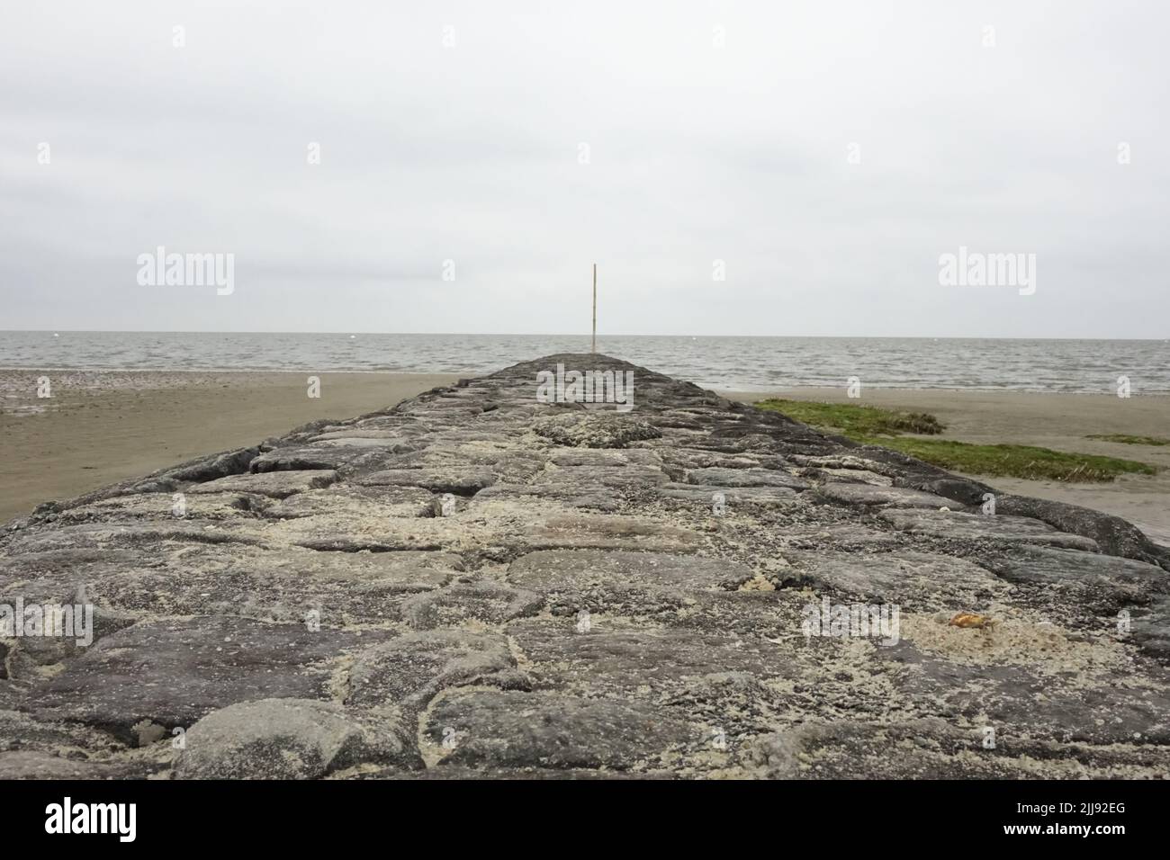 A sandy stone path on the beach of Sahlenburg under the gloomy sky ...
