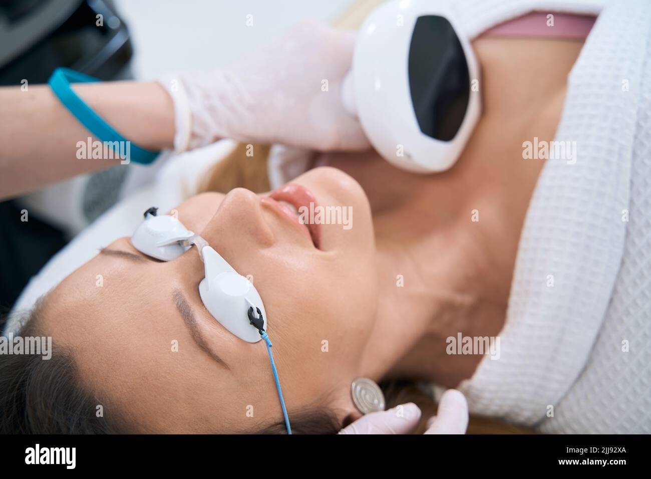 Woman in cosmetology center undergoes a neckline skin rejuvenation ...