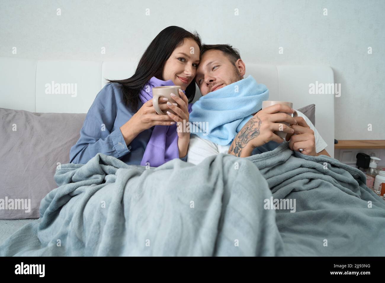 Cute couple basking in bed with a cup of tea Stock Photo - Alamy