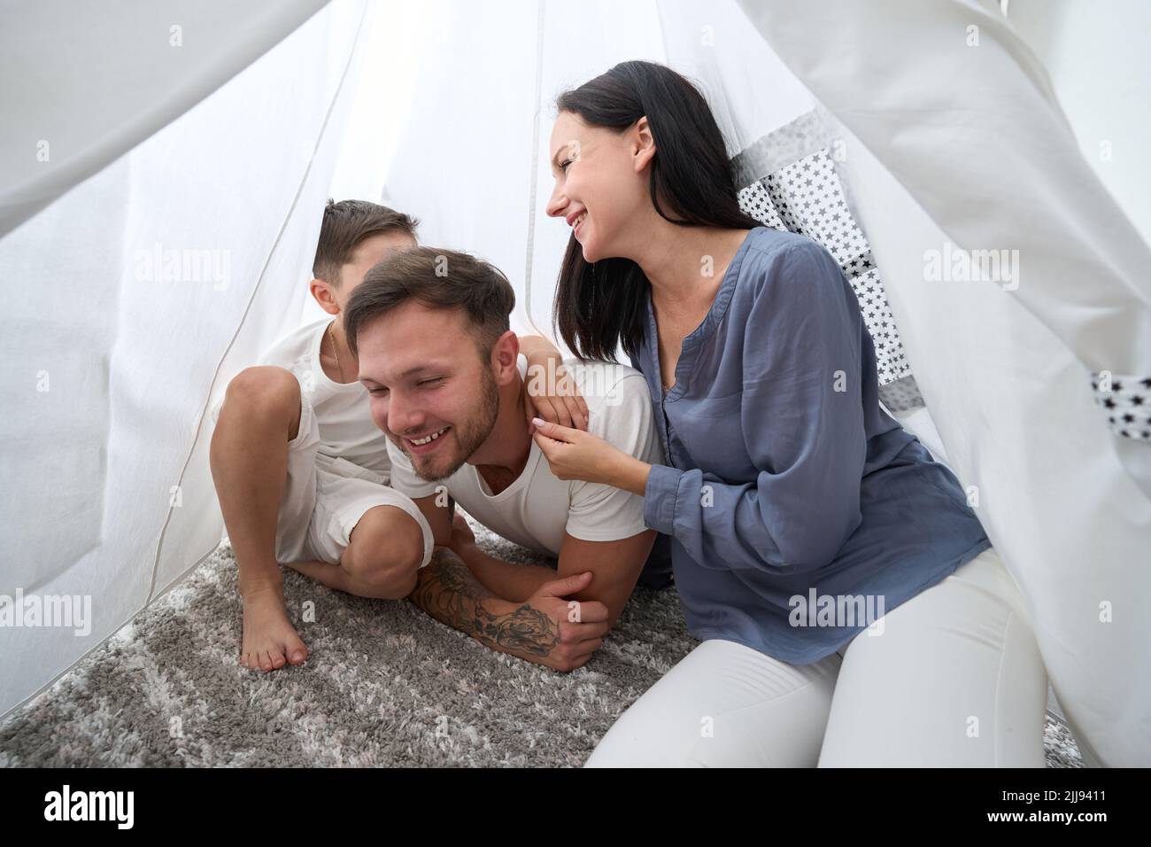 Cheerful hugs of parents and son in fairy tale hut Stock Photo - Alamy