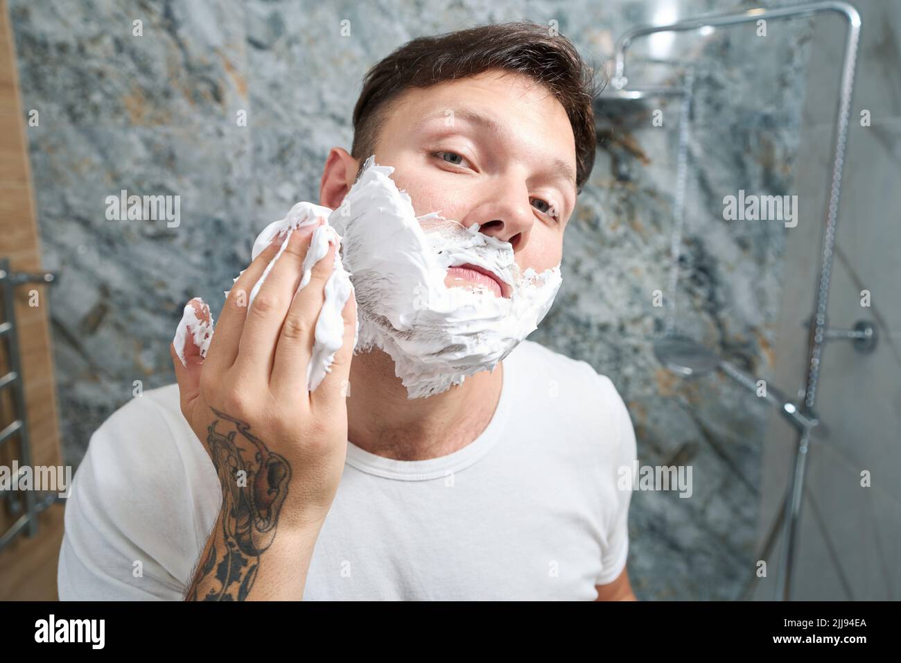 Man applying shaving cream to his cheeks Stock Photo - Alamy