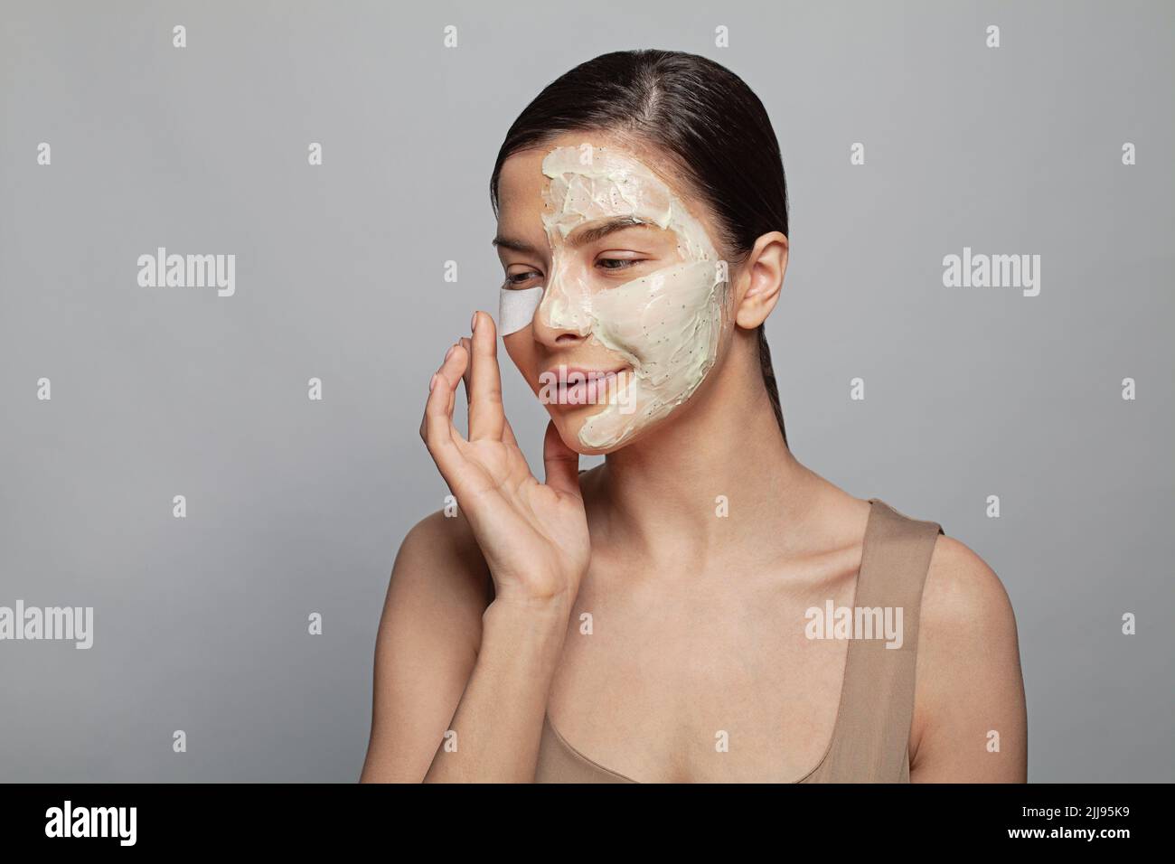 Healthy attractive young woman with cosmetic mask on her skin, skincare ...