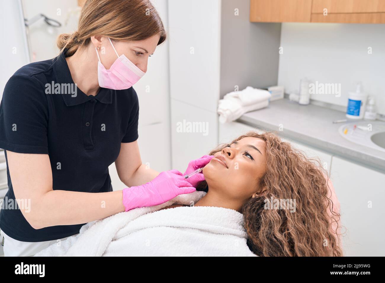 Employee of medicine center conducts session of botulinum toxin ...