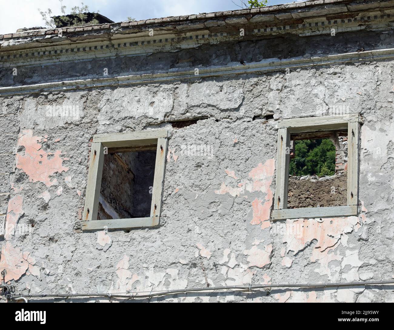 two windows without the frames of a completely destroyed house without ...