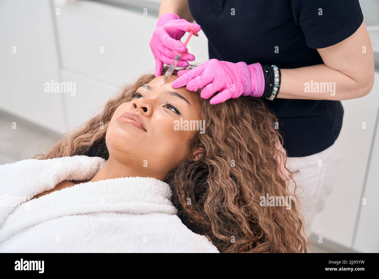 Young woman receives botulinum toxin injections in a cosmetology clinic ...
