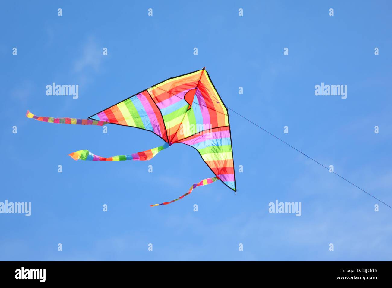colorful kite with many colors red yellow green orange flying very high ...