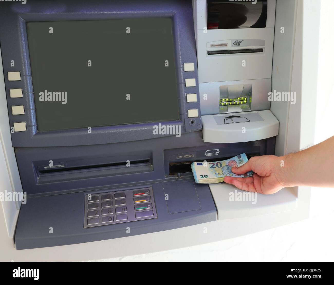 Hand picking up European banknotes from an ATM after entering the ...