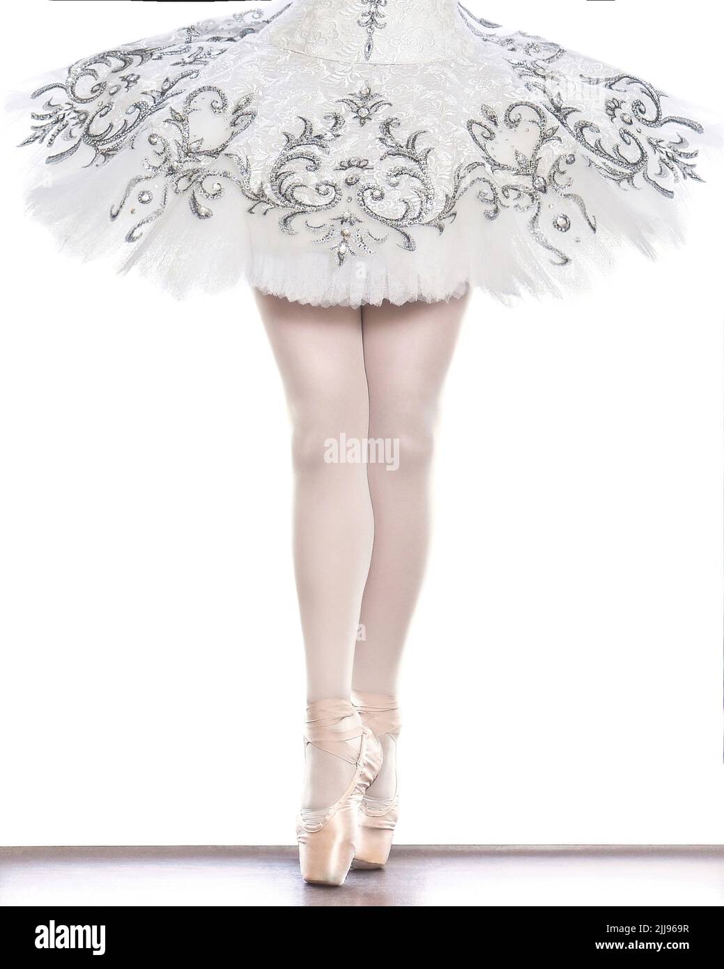 Legs of a young ballerina on pointe balancing on the tips of her toes ...