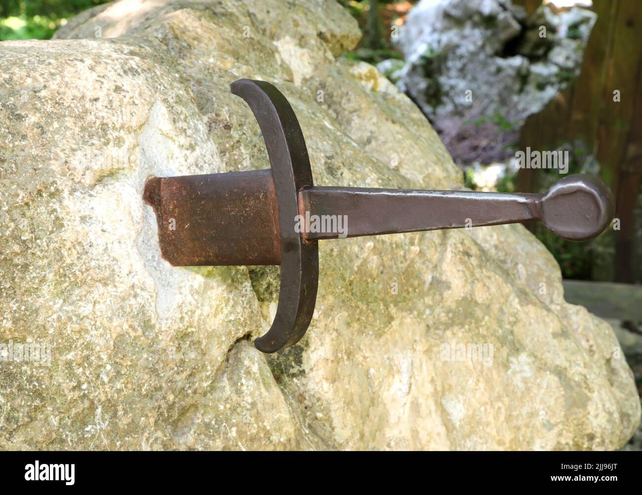 sword embedded in the stone in the middle of the forest of trees symbol ...