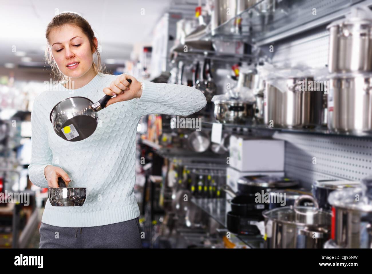 Female is choosing modern pan for her kitchen Stock Photo - Alamy