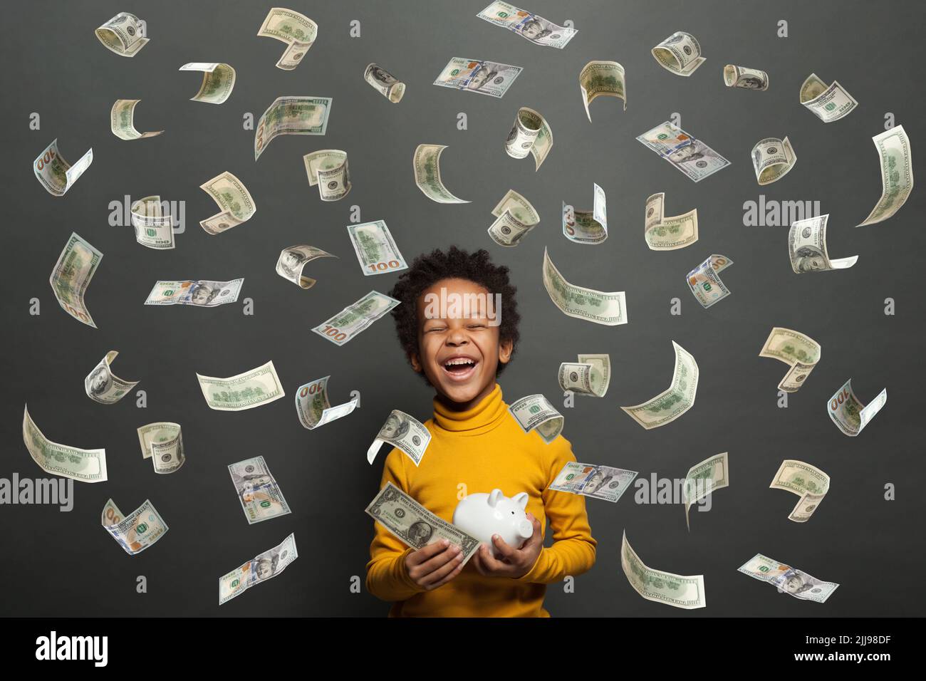 Happy african american kid laughing and holding white piggy bank in ...