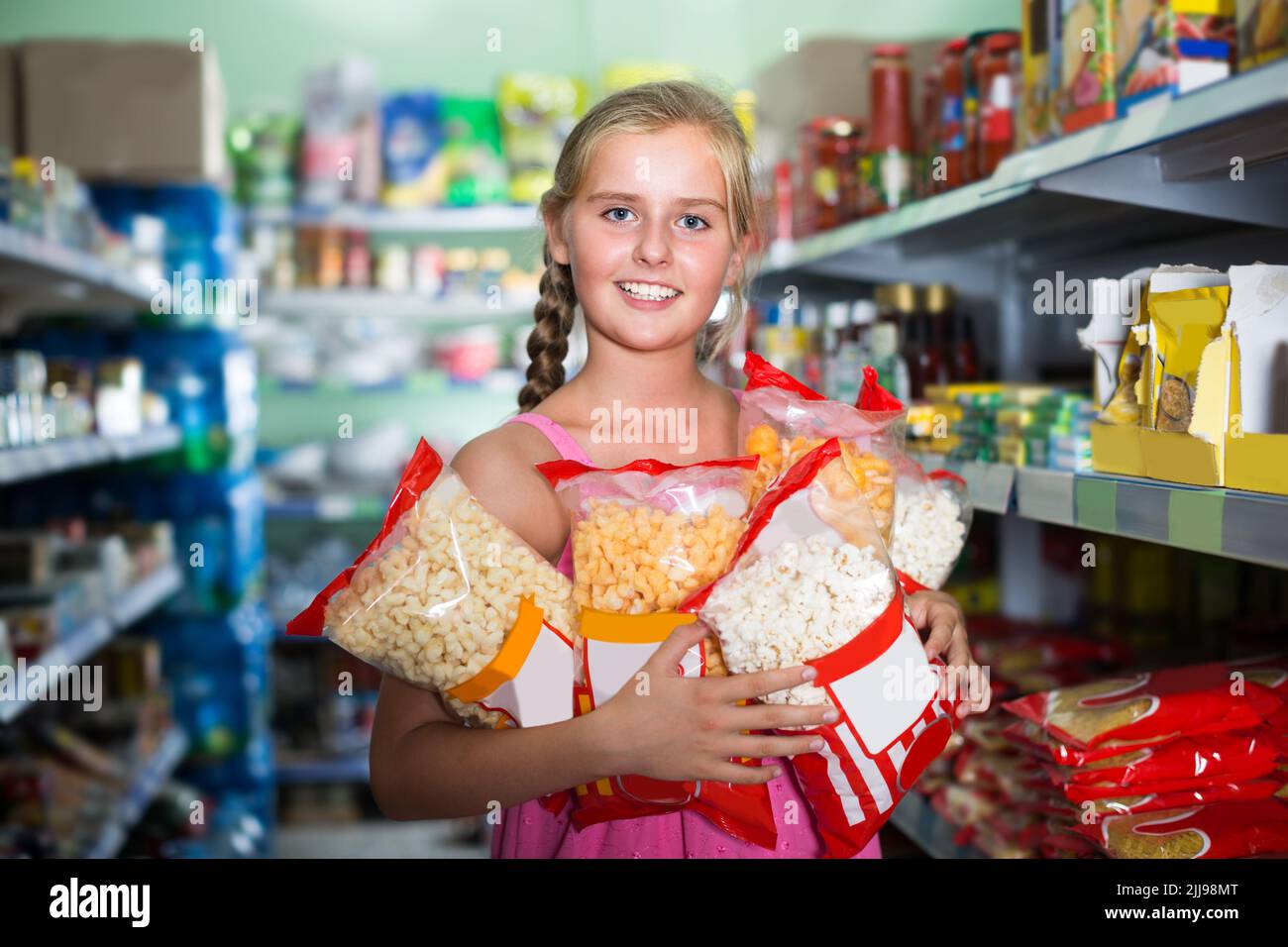 Customer girl is standing with packets of popcorn Stock Photo - Alamy
