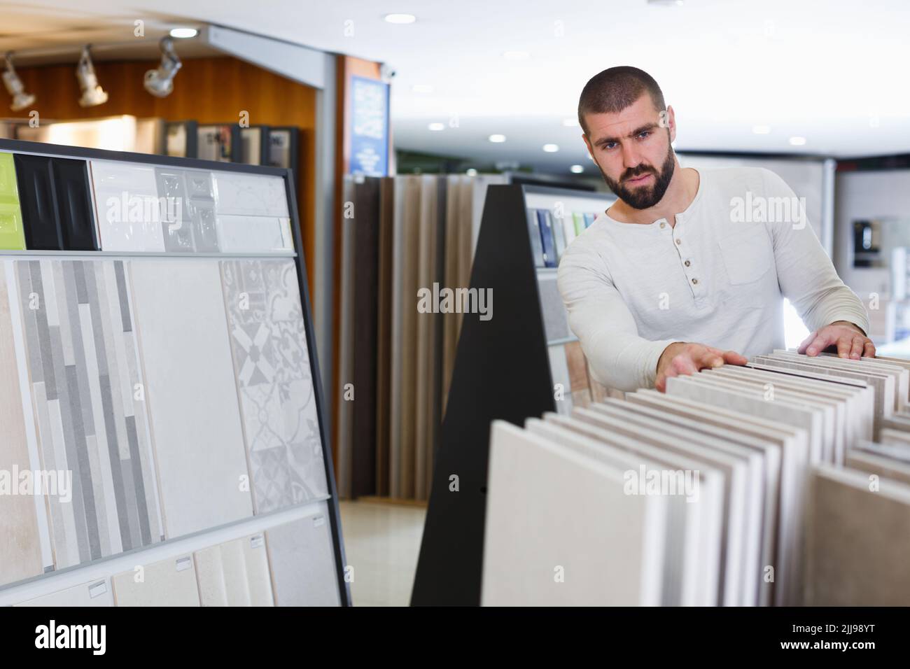 Portrait of man customer choosing ceramic tile in shop Stock Photo - Alamy
