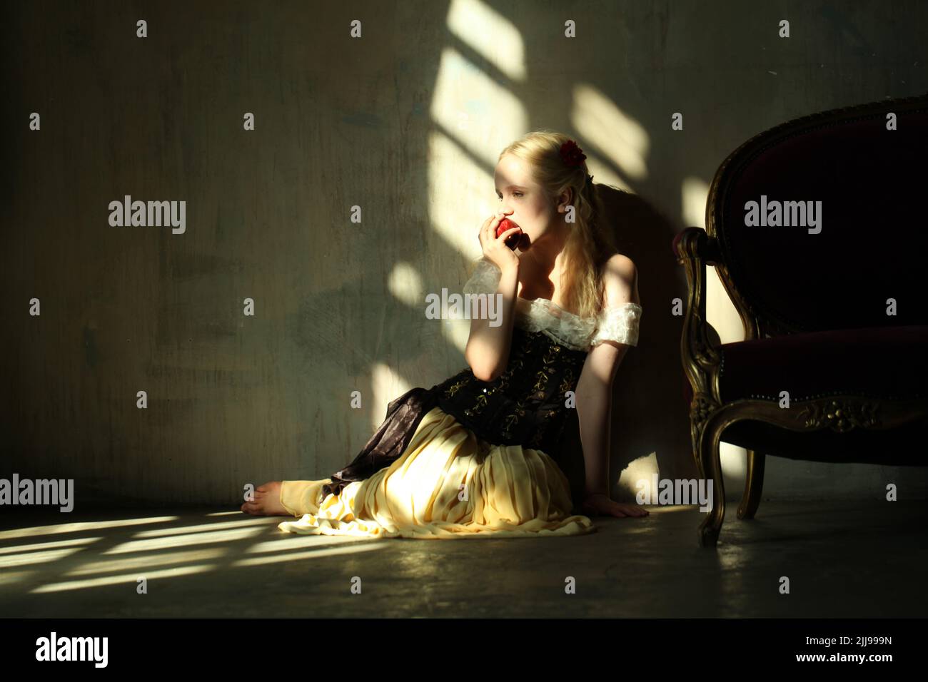 Beautiful woman in retro dress eating red apple indoor Stock Photo - Alamy