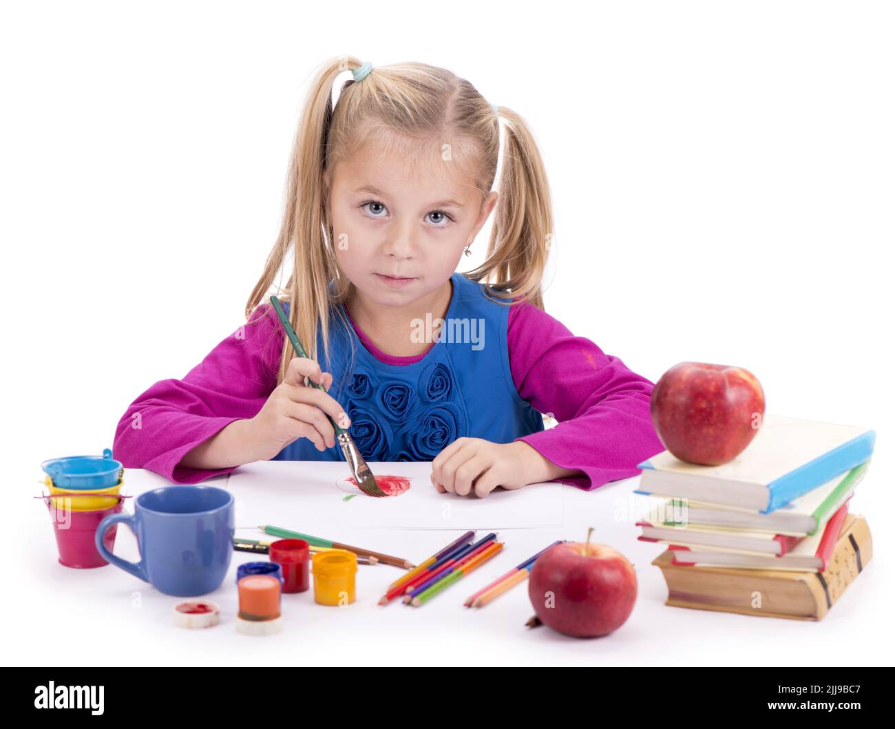 Children's hobbies, creativity, a little girl in a blue dress draws ...