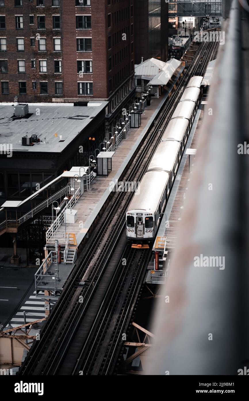 A vertical shot of a train at railway station between buildings Stock ...
