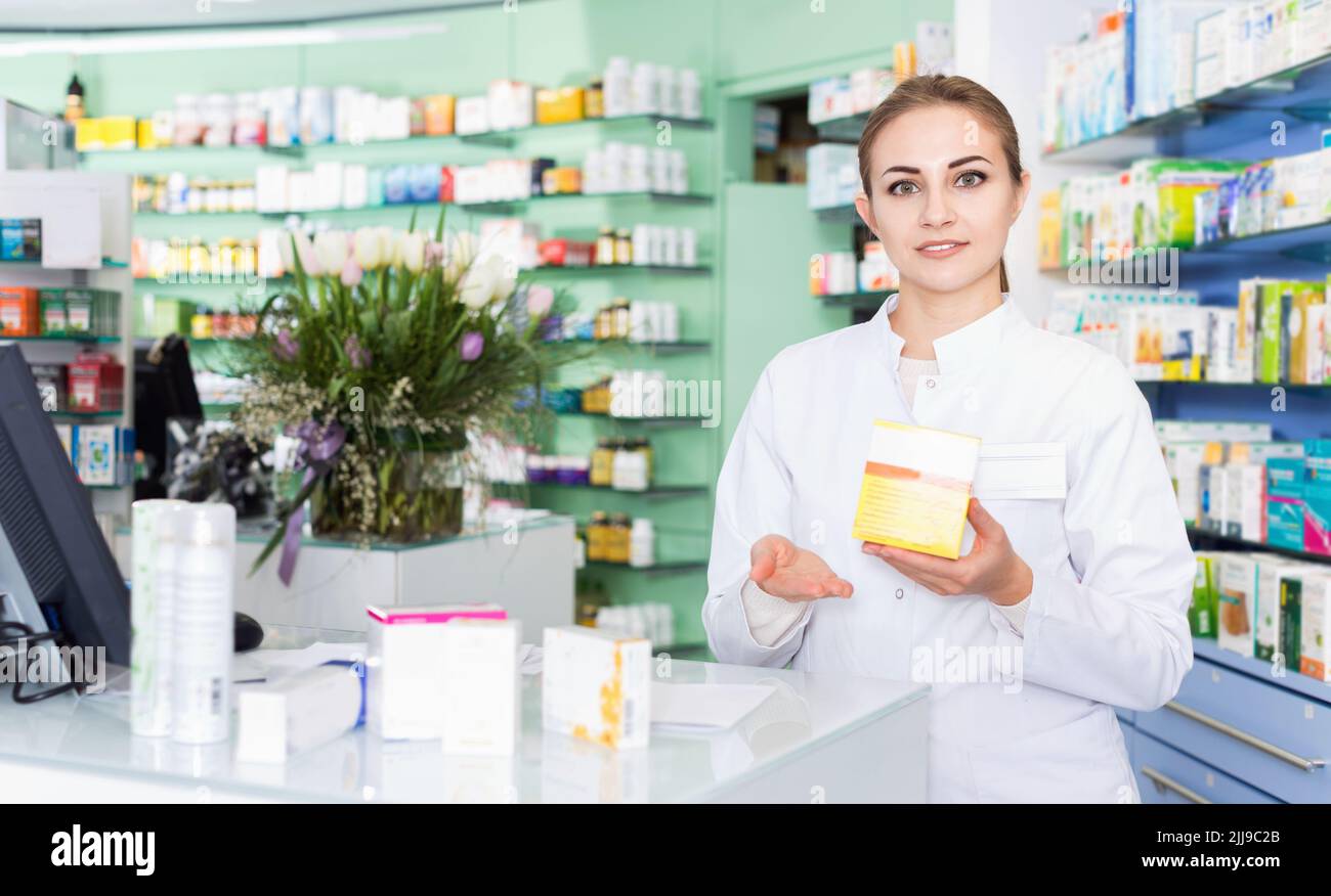 Portrait of woman pharmacist who is standing on her work place near ...