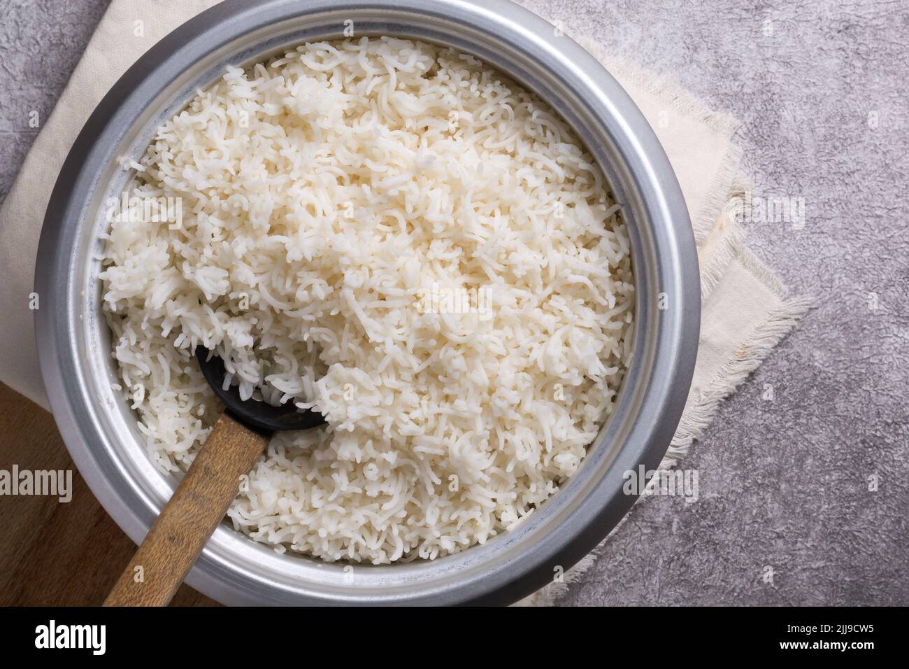 pot of cooked white basmati rice with a wooden spoon, just cooked long ...