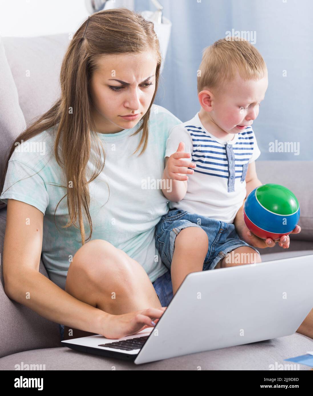Female is having problems with kid while working Stock Photo - Alamy