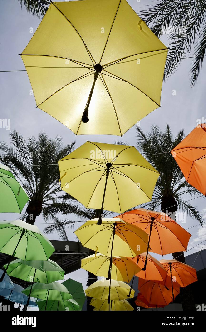 A group of different colored umbrellas hang overhead a walkway Stock ...