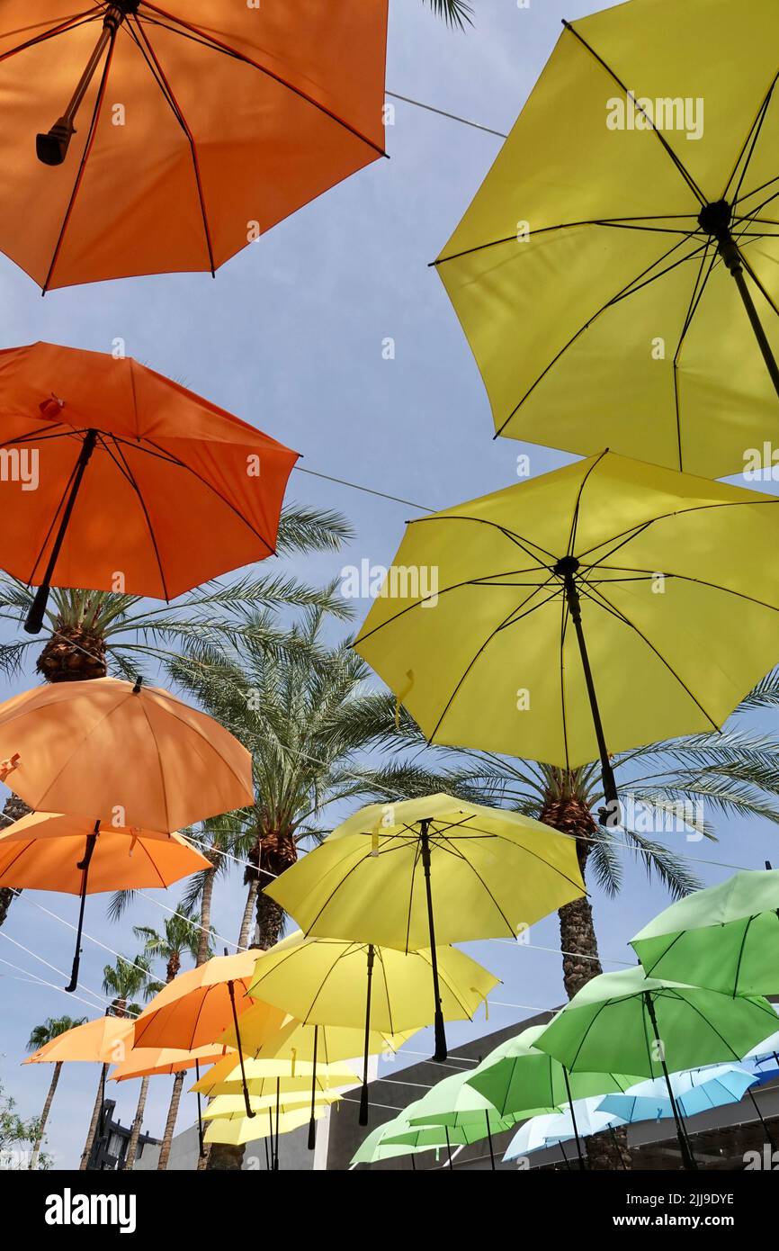 A group of different colored umbrellas hang overhead a walkway Stock ...