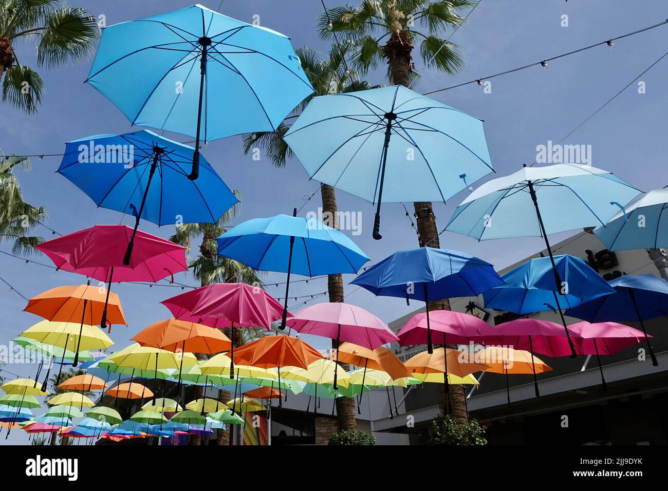 A group of different colored umbrellas hang overhead a walkway Stock ...
