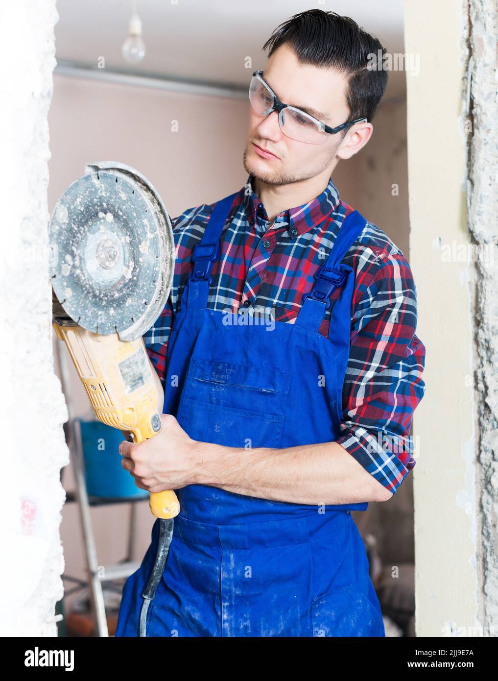 Male using professional angle grinder Stock Photo - Alamy