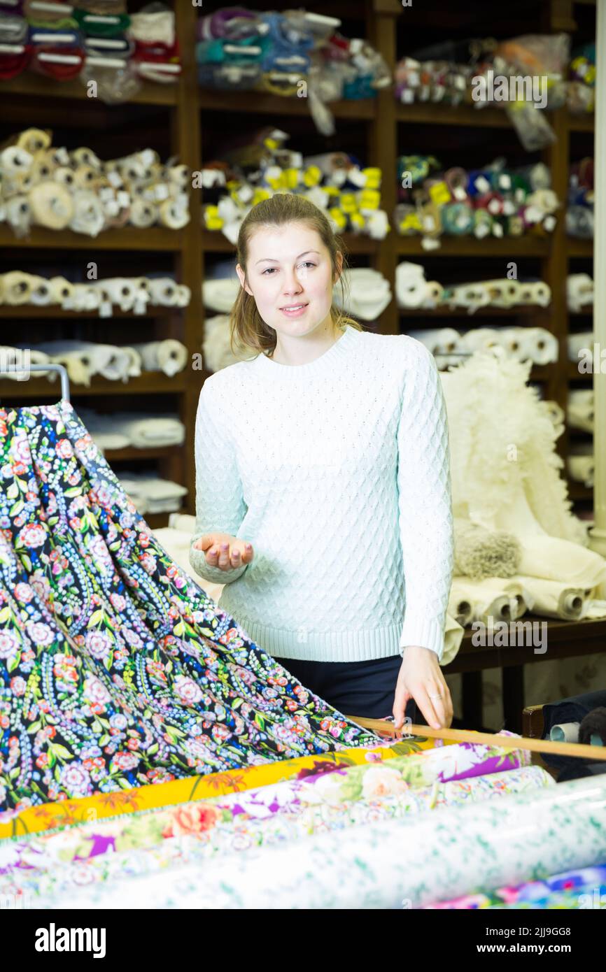 Female seller of fabric shop showing textiles Stock Photo - Alamy