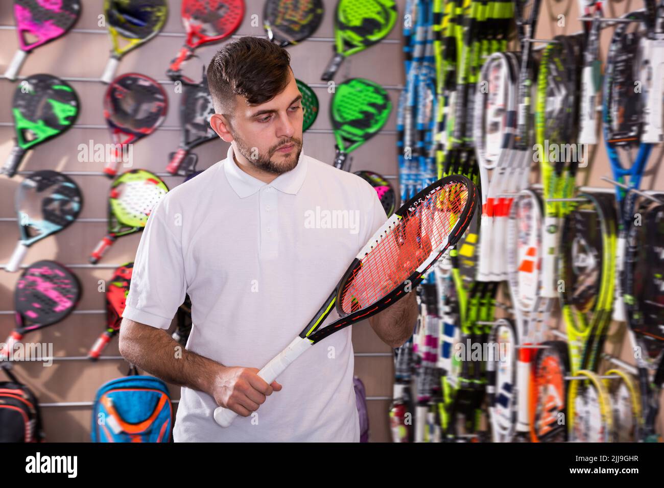 Nice man looking for modern tennis racket Stock Photo - Alamy