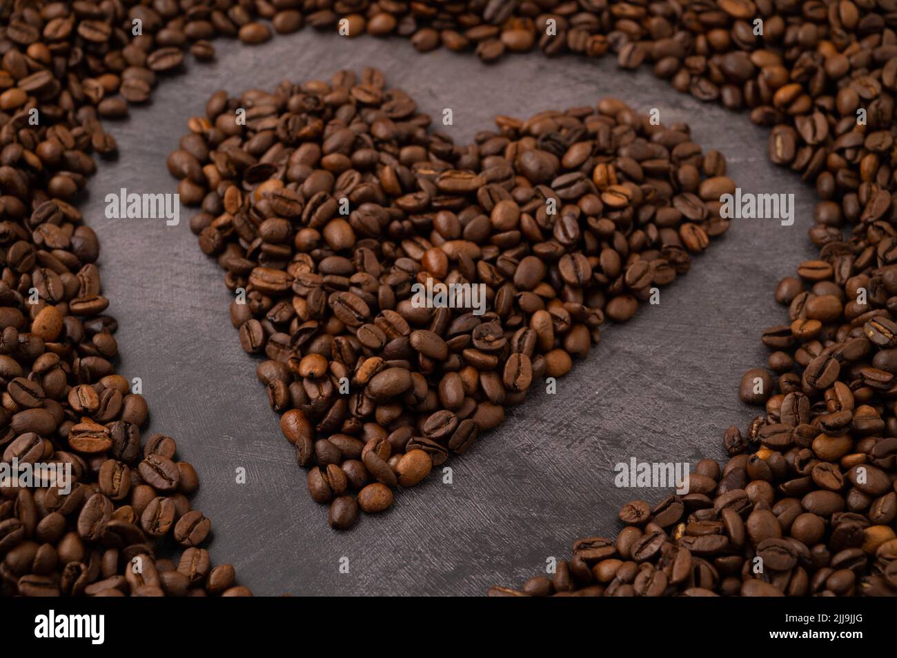 Coffee beans in the shape of a heart on a metal table top. Valentine's ...