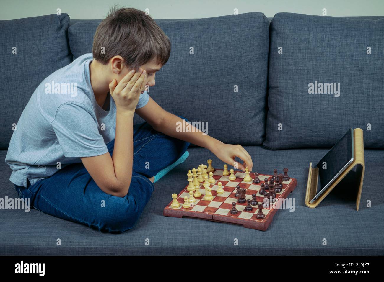 Teenage boy learning to play chess online with tablet computer. Online ...