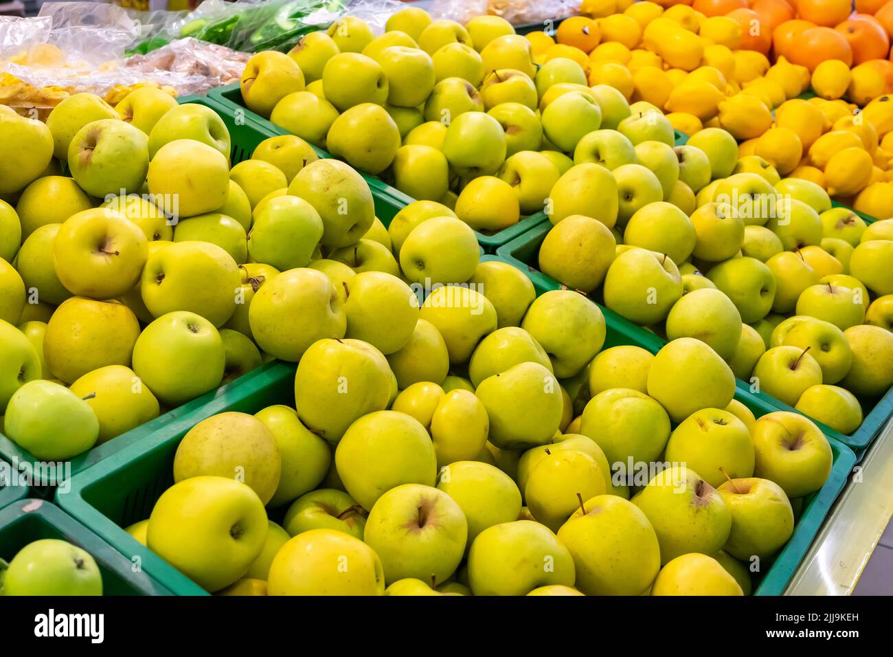 Pile of apples on the stall in the supermarket. Green apples in boxes ...