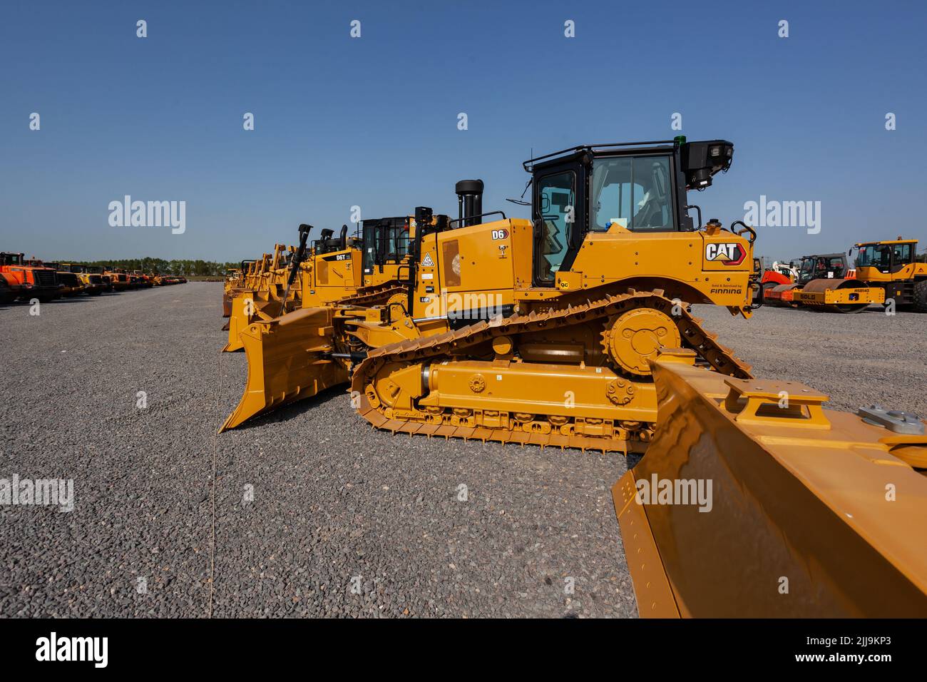 A row of bulldozers with track pads under a clear blue sky Stock Photo ...