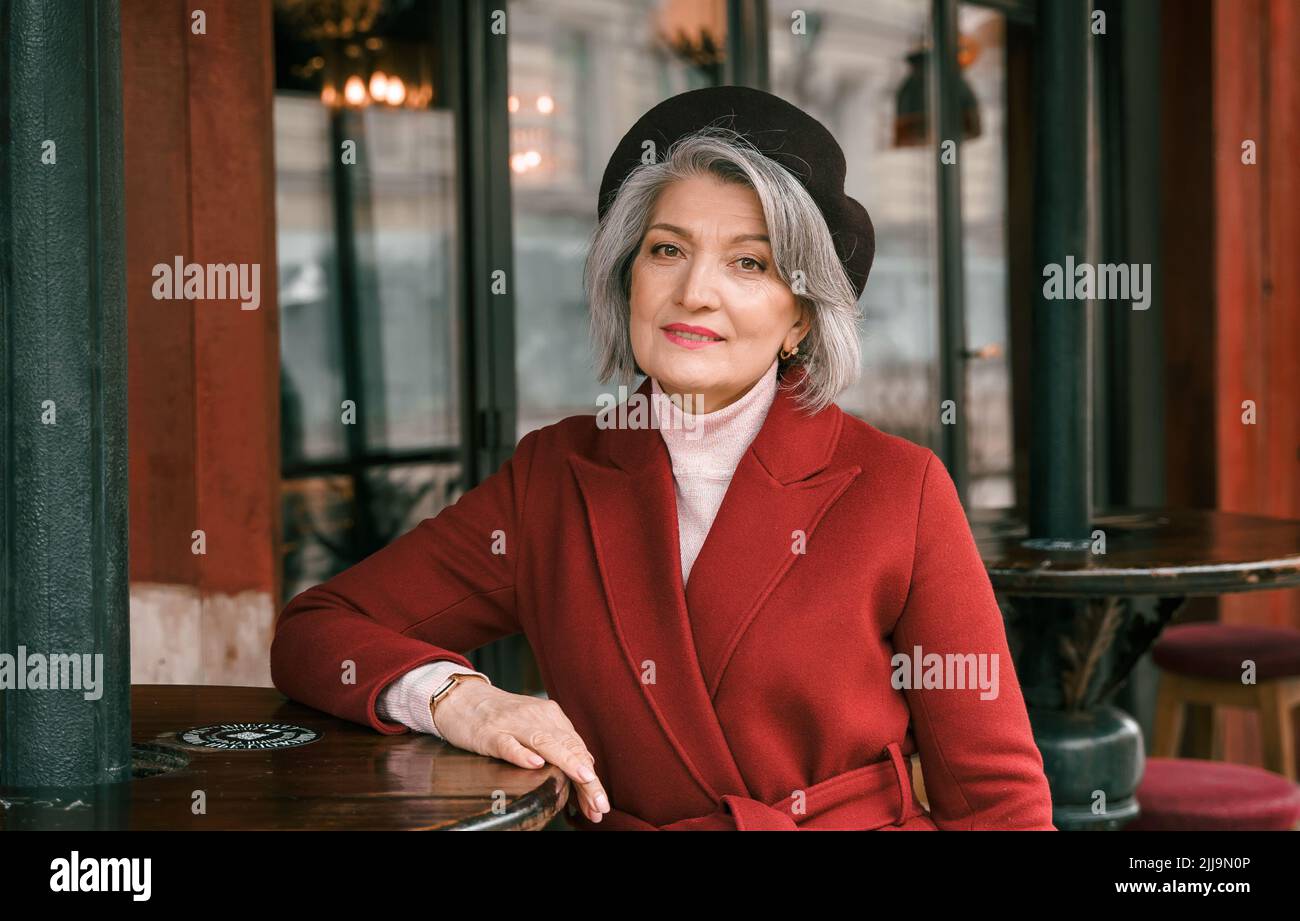 Elderly senior woman walking at cafe table in restaurant. Old retired ...