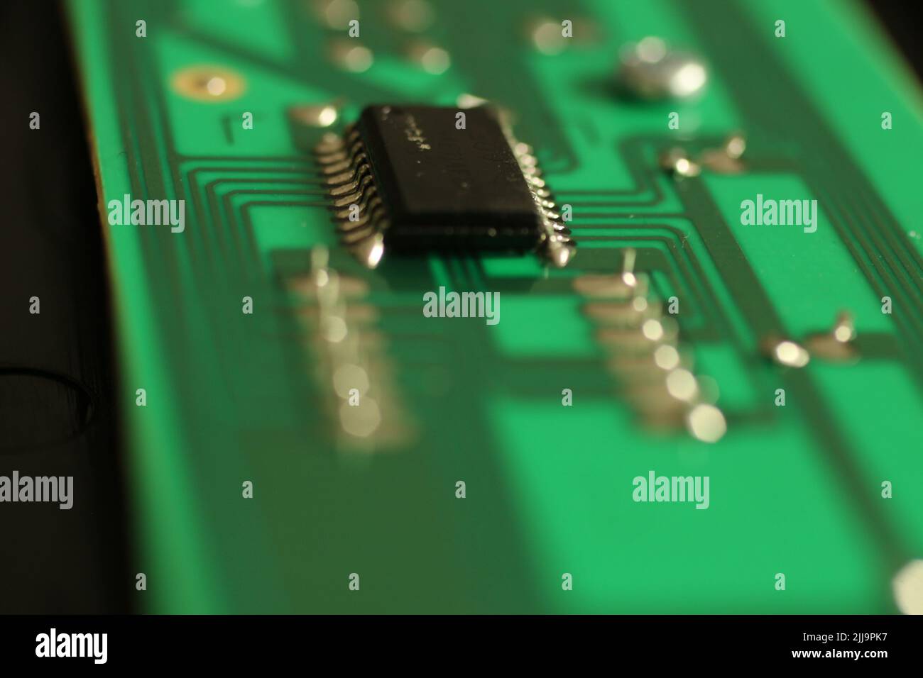 Close up of an electronic component on a green circuit board with deep ...