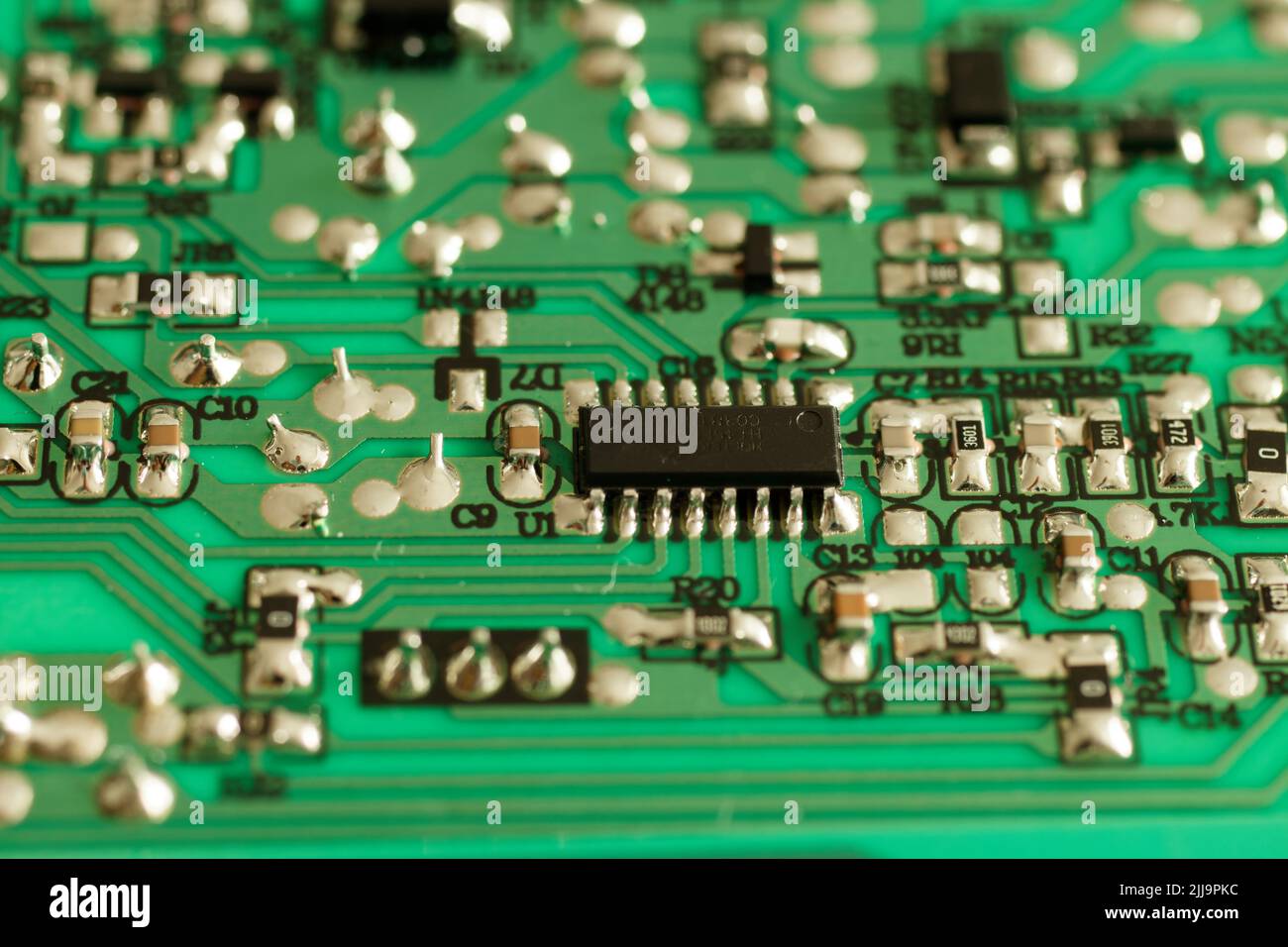 Close up of an electronic component on a green circuit board with deep ...