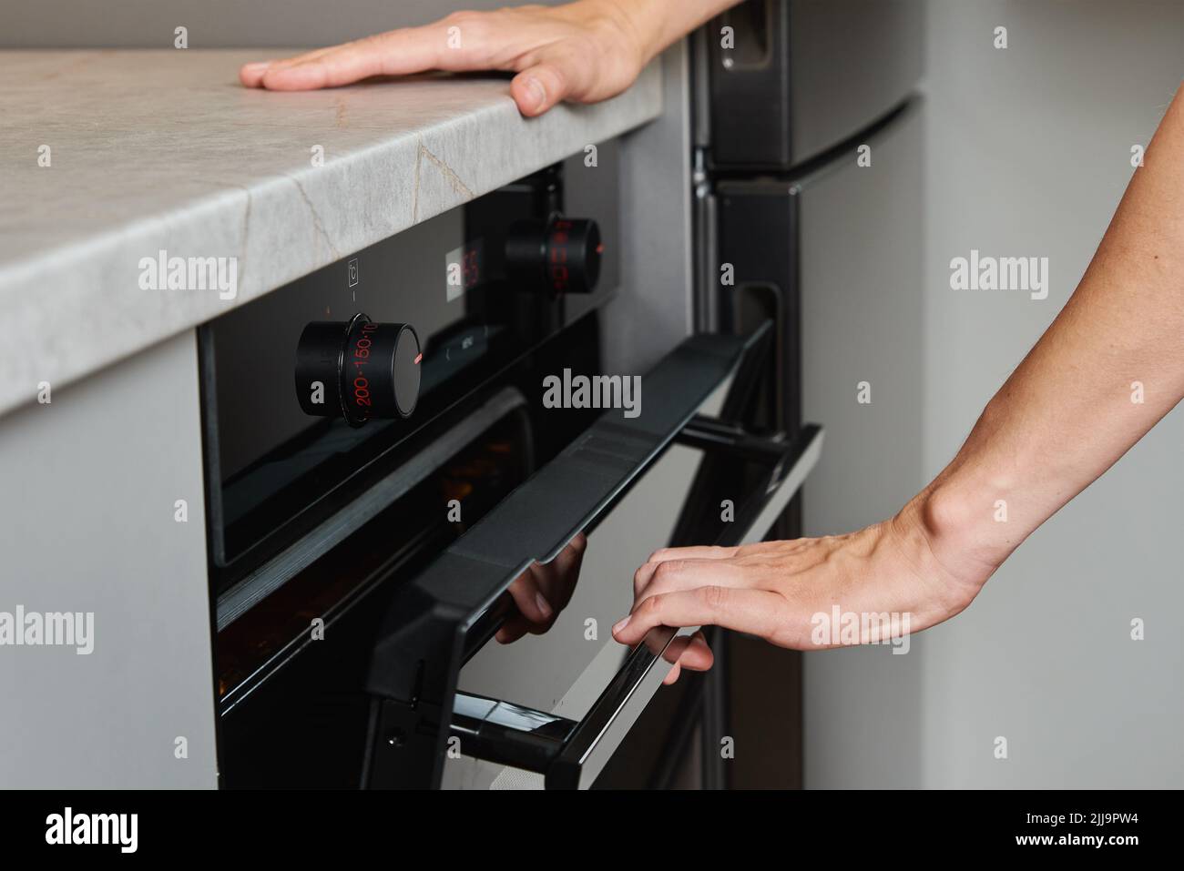 Female hand open electric oven door with handle, Woman using electric ...