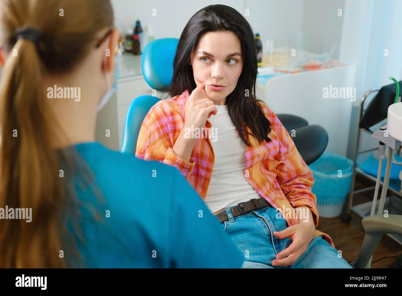 Dentist and patient talk about dental treatment. Consultation of ...