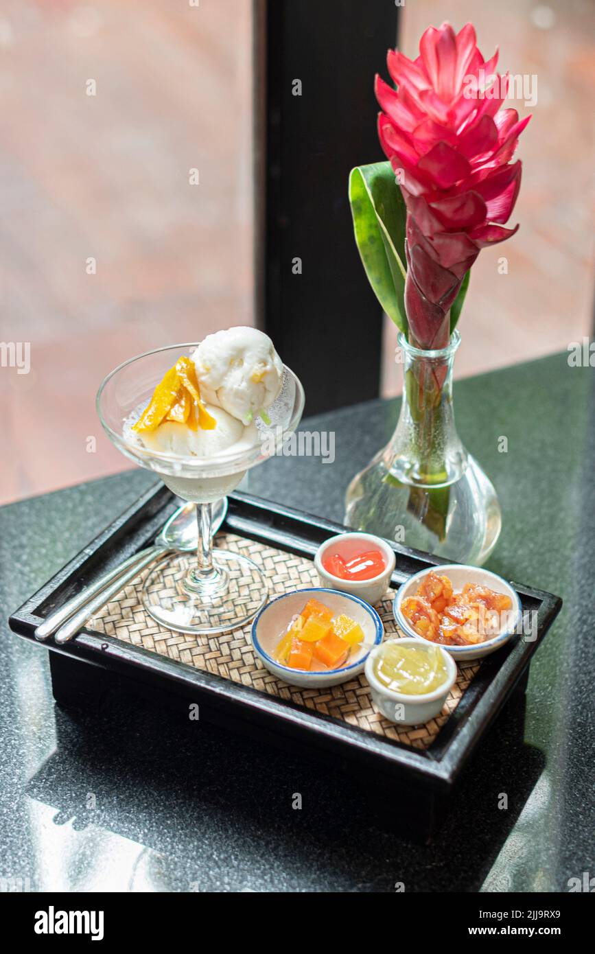 A vertical shot of beautifully plated ice cream with various toppings ...