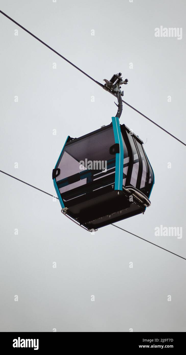 A vertical bottom view of cable car ,blue gondola cabin going under ...