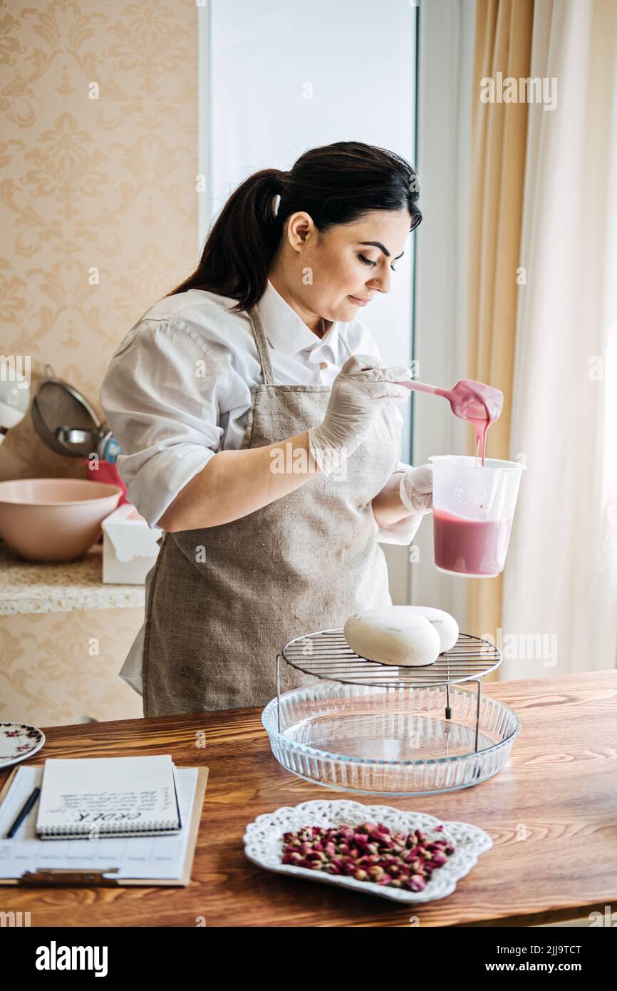 Central Asian Arabic woman pastry chef making Mirror Glaze Mousse cake ...
