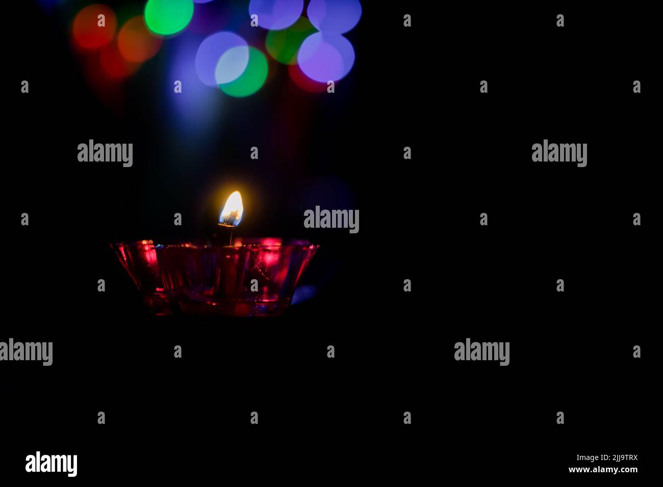 Diwali Diya made of glass in red color with colorful Bokeh at ...