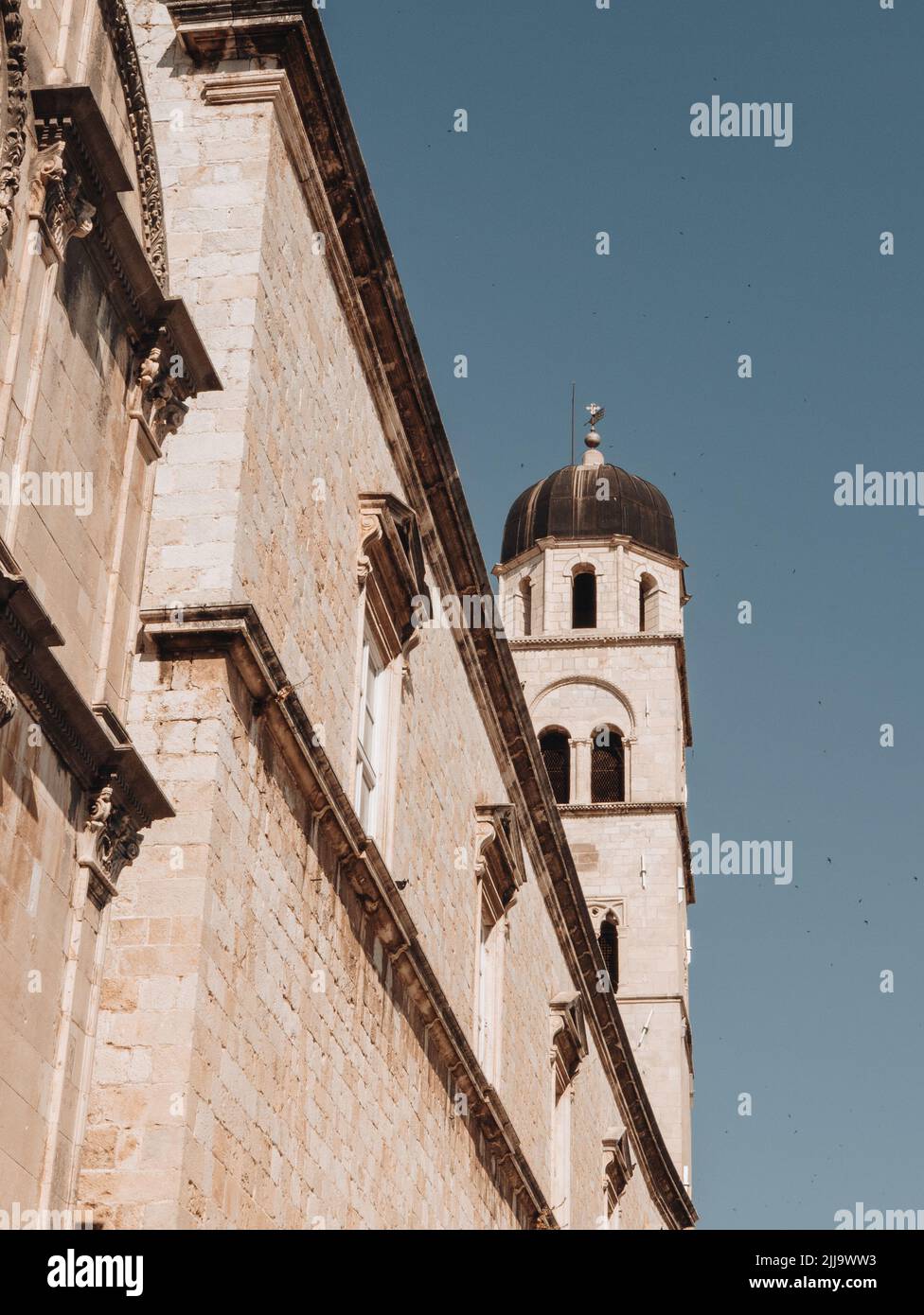 A low-angle shot of a brick tower and building from the side with a ...
