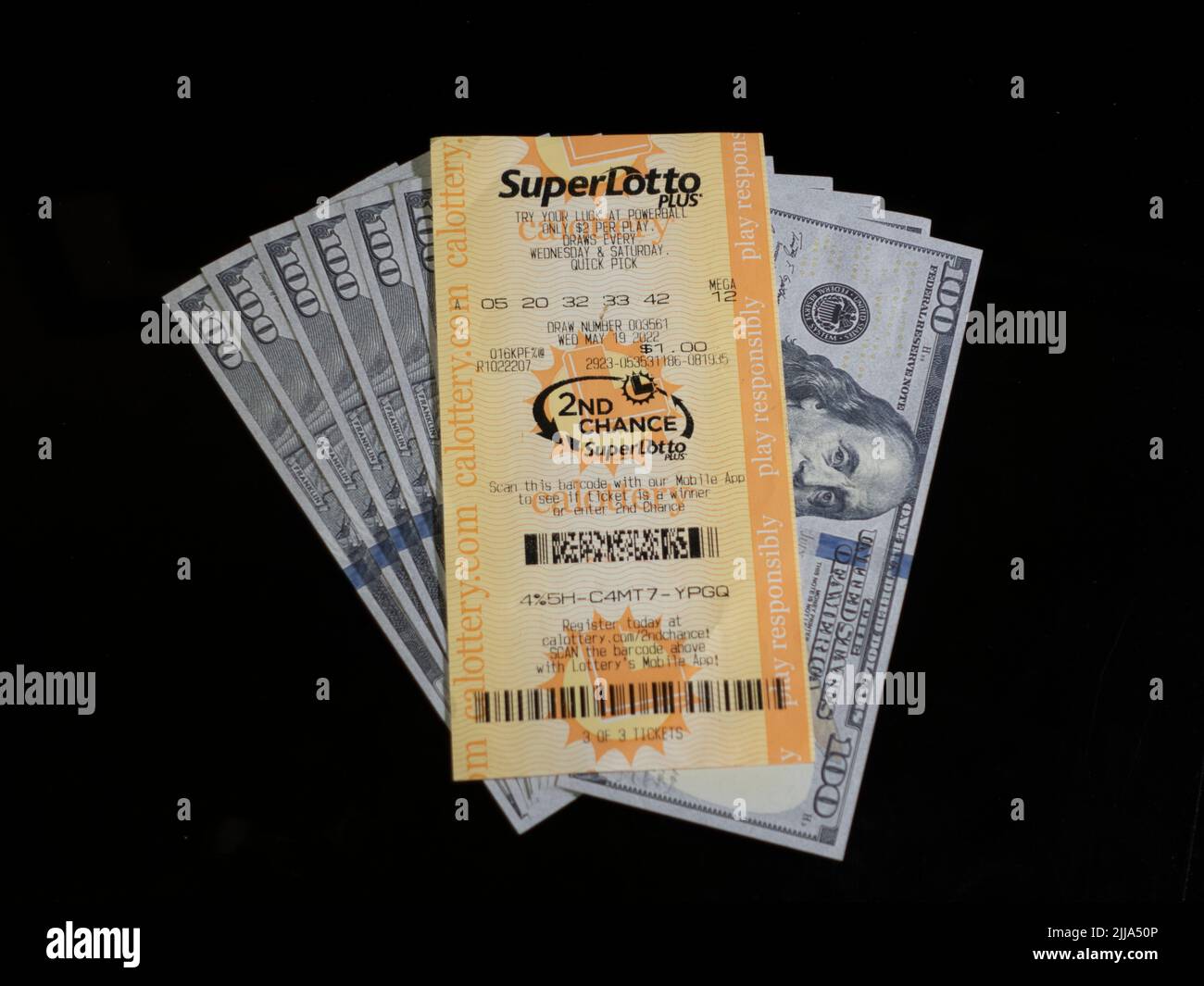 Lake Elsinore, CA, USA - May 19, 2022: Lottery ticket on fan of 100 USD ...