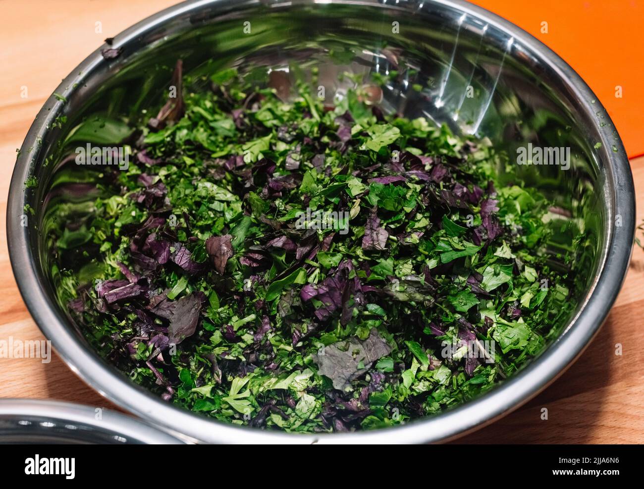 Finely chopped fresh edible herbs while cooking, a large pile in a ...