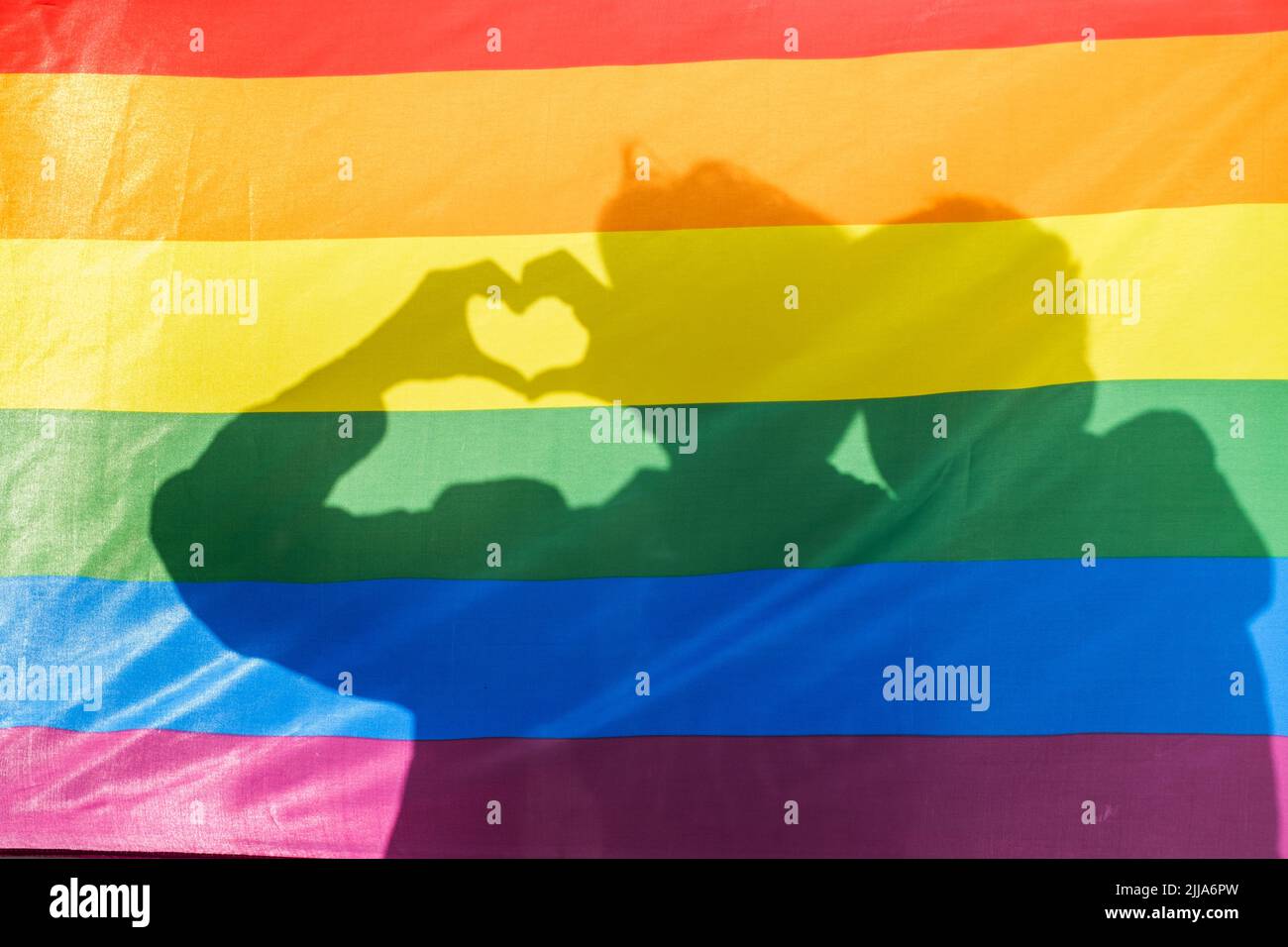 Two shadows of young people behind an lgtbi flag Stock Photo - Alamy