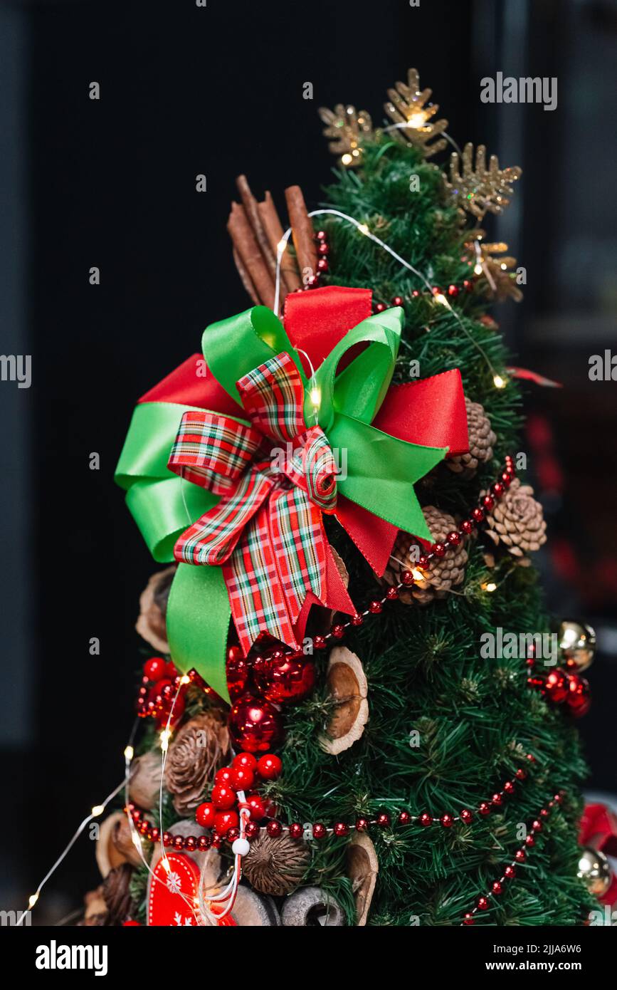 the tip of an evergreen tree decorated to celebrate Christmas and the ...