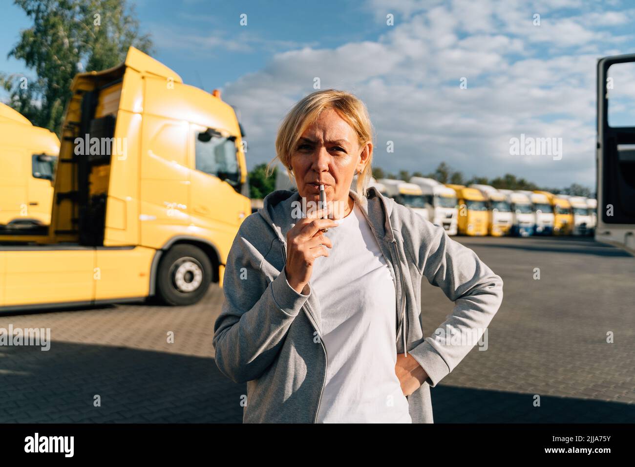 Caucasian mature woman in middle age working as a truck driver. Smoking ...